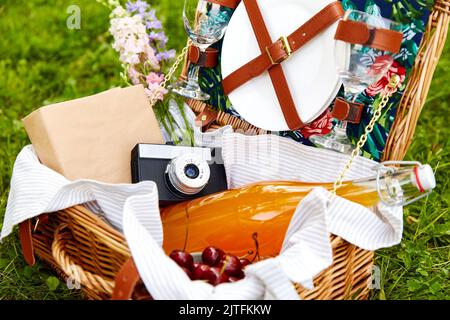 juice, cherry, book and camera in picnic basket Stock Photo - Alamy