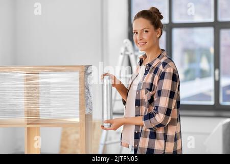 woman packing shelf and moving to new home Stock Photo - Alamy