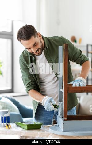Young hispanic man with beard painting on canvas at home looking ...