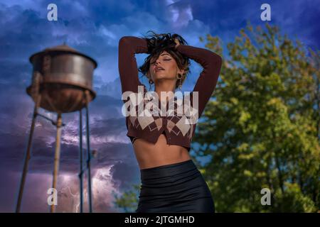 A gorgeous brunette model poses outdoors while enjoying the autumn ...