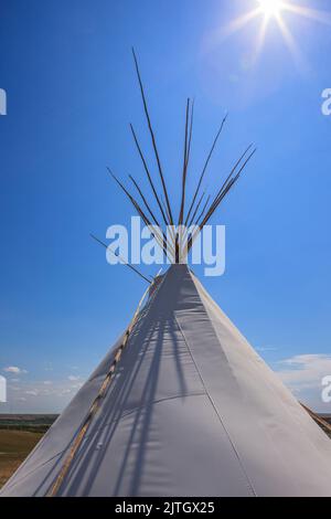 A conical tipi (or teepee) built with canvas stretched over a frame of ...
