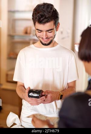 Male shopping assistant helping customer to buy pomegranate fruit in ...