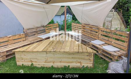 Patio table and benches made from pallets with a canvas roof Stock ...