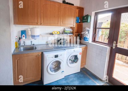 A utility room in a house in the UK showing a washing machine and waste ...