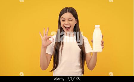 winking child hold dairy beverage product. teen girl going to drink ...
