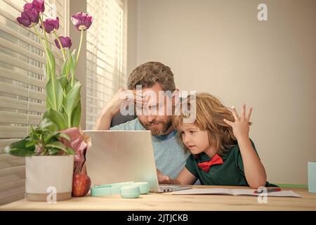 bearded dad or school private tutor teaching boy son with modern laptop ...