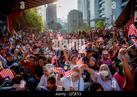 People gather with flags of Malaysia to witness the National Day parade ...