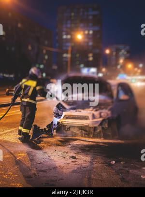 Group of fire men extinguishing and put out burning car crash after ...