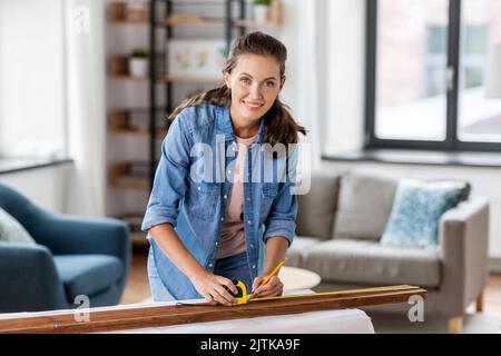 woman with ruler measuring wooden board Stock Photo - Alamy