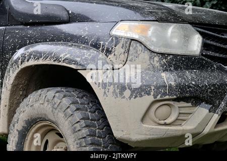 SUV covered in mud. The wheels and body of the car are splattered with ...