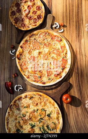 Three pizzas of different flavors. Pepperoni, cheese, potato, onion ...