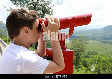 Kid examines Azish-Tau ridge through binoculars, Adygea Stock Photo - Alamy