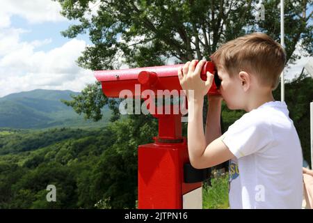 Kid examines Azish-Tau ridge through binoculars, Adygea Stock Photo - Alamy