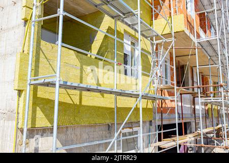 Applying thermal isolation stone wool on the brick wall of residential ...