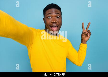 Portrait of attractive cheerful hippie guy holding in hand blue round ...