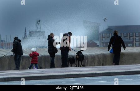 A FAMILY ENJOY A BRACING WALK ALONG THE SEAFRONT AT SOUTHSEA DODGING ...