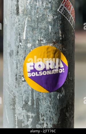 sticker pasted on a post, with the words in brazilian portuguese "fora ...