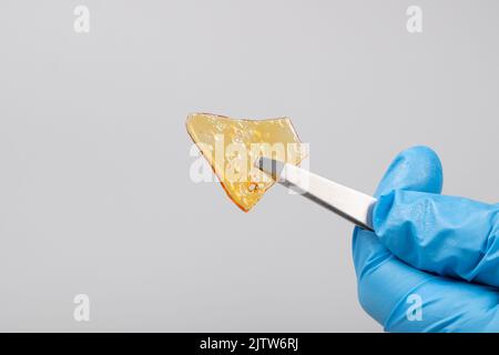 yellow wax piece with high THC on gray background Stock Photo - Alamy