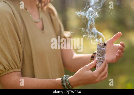 woman with sage performing magic ritual in forest Stock Photo - Alamy