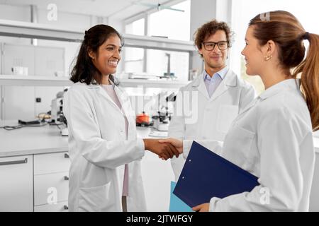 scientists shaking hands in laboratory Stock Photo - Alamy