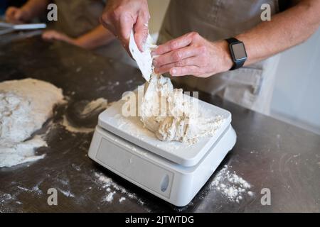 The process of making bread. Dividing the wheat dough into pieces for ...