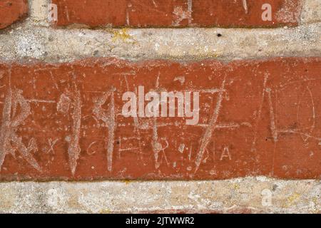 Signature wall. A photo of brick wall of an old school with a lot of ...