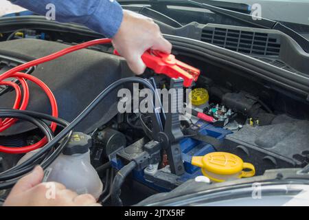 broken down car with low battery. Starting with cables Stock Photo - Alamy