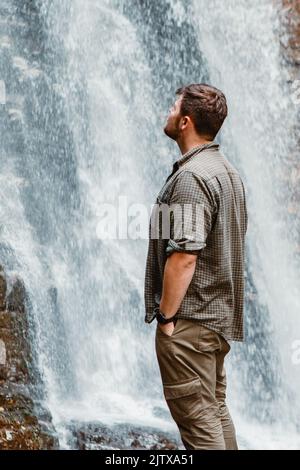 young strong man hiker looking the waterfall copy space Stock Photo - Alamy