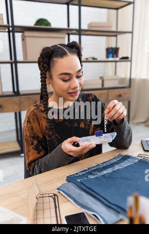 Smiling craftswoman holding scissors in a bright tailor workshop Stock ...