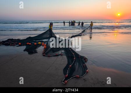 Fishermen preparations for rowing boat fishing nets on beach shoreline ...