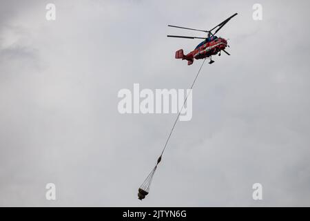 Bottom view of a helicopter carries a cargo of military supplies in ...