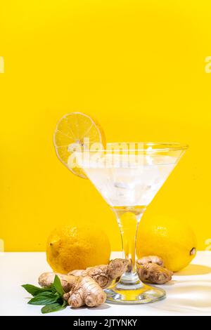 Ginger lemon martini. Sour tasty alcohol cocktail on white and yellow ...