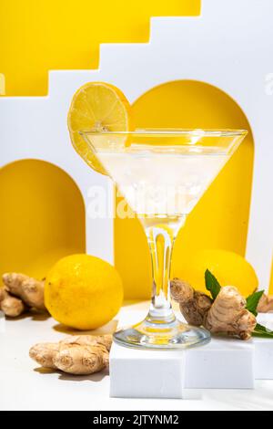 Ginger lemon martini. Sour tasty alcohol cocktail on white and yellow ...