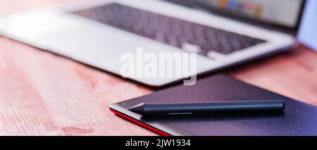 Graphic designer's workplace. Laptop and graphics tablet on a wooden ...