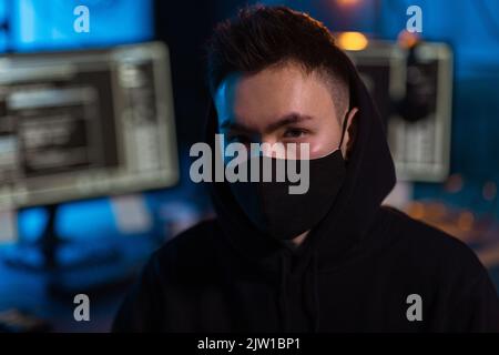 hacker wearing mask with computers in dark room Stock Photo - Alamy