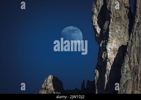 A rocky cliff with the fading moon in the background Stock Photo - Alamy