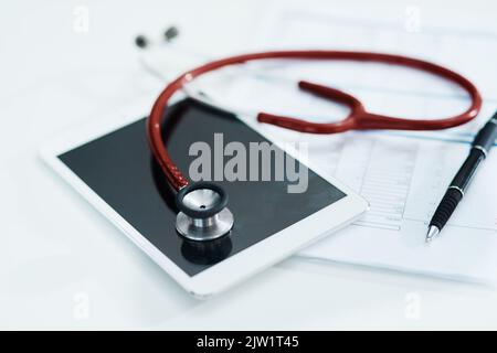 Tablet pc and doctor tools on white surface Stock Photo - Alamy