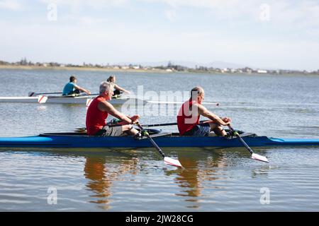 Two senior caucasian rowing teams rowing the boat on the lake Stock ...