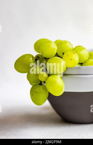 Stoneware with ripe green grape on concrete background Stock Photo - Alamy