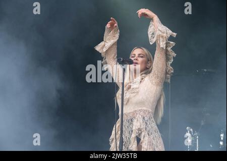 Lyra - singing to the connect audience wearing a lace thrilled blouse ...