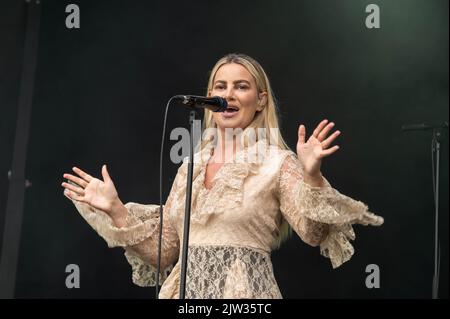 Lyra - singing to the connect audience wearing a lace thrilled blouse ...