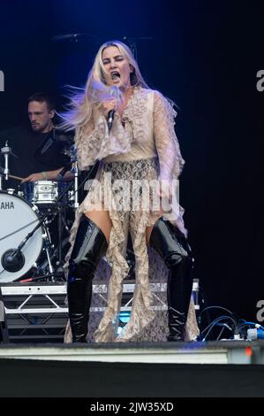 Lyra - singing to the connect audience wearing a lace thrilled blouse ...