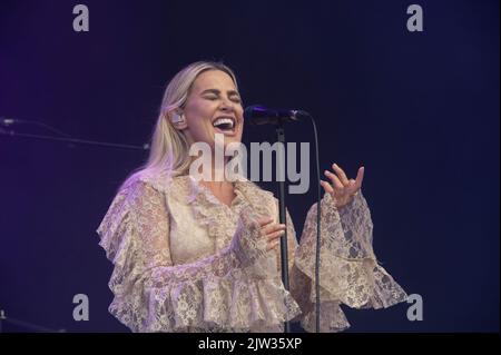 Lyra - singing to the connect audience wearing a lace thrilled blouse ...