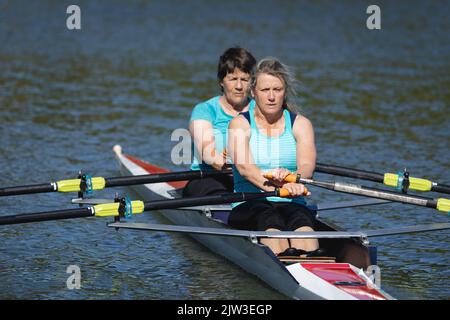 Two senior caucasian female rowers rowing the boat on the lake Stock ...
