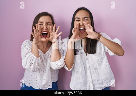 Hispanic mother and daughter together shouting and screaming loud to ...