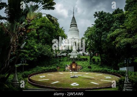 The stupa at Wat Phnom is seen in front of a large clock ornament made ...