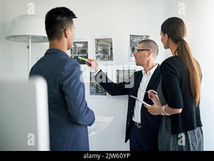 Developing a gameplan. three colleagues working in the office Stock ...