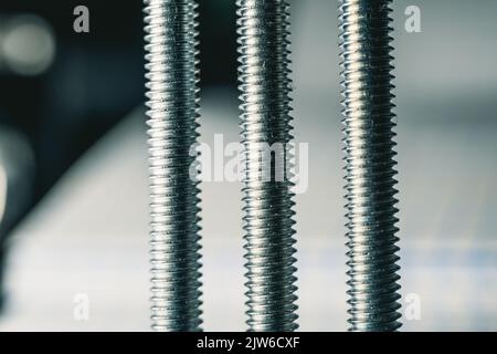 A closeup shot of metallic screws with a blur background of a graph ...