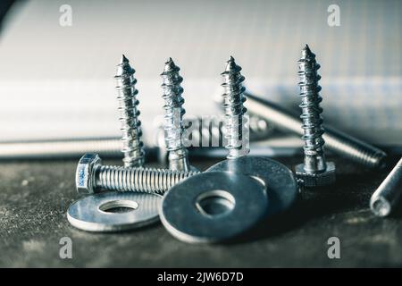 A closeup shot of metallic screws with a blur background of a graph ...