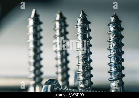 A closeup shot of metallic screws with a blur background of a graph ...